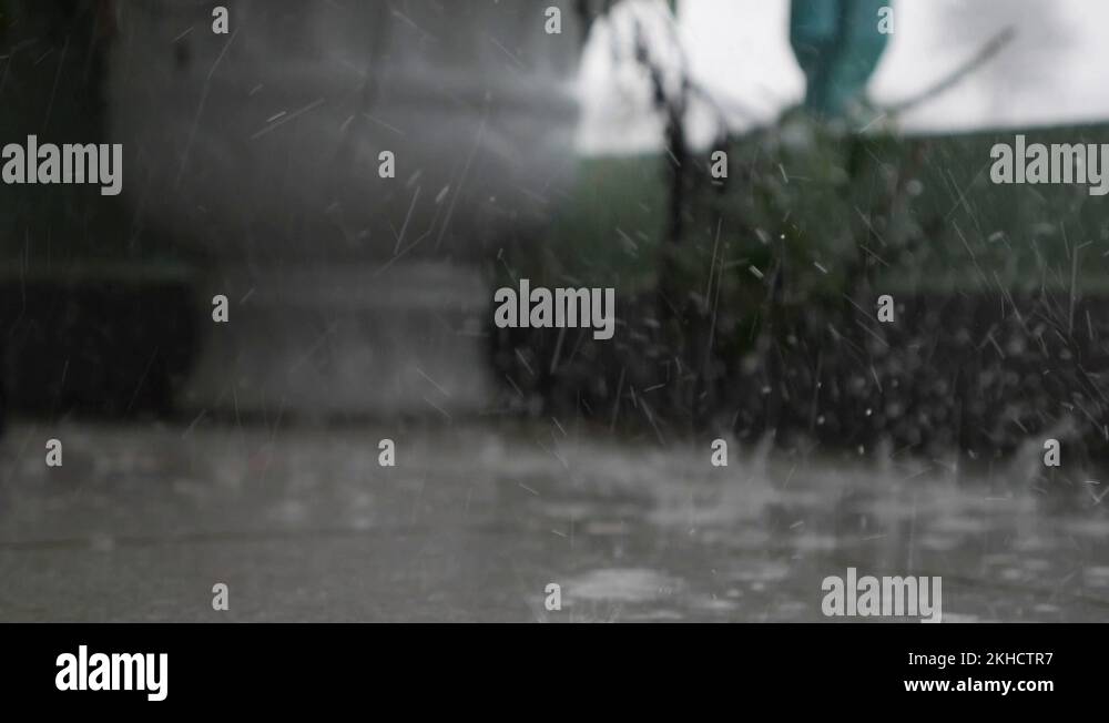 Close-up, large, heavy drops of rain fall with a spray. Water splashes ...