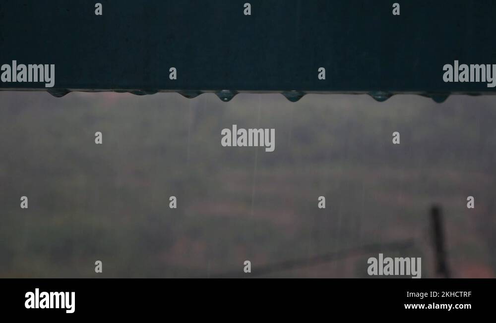 Drops of water dripping from the railing on the balcony during heavy ...