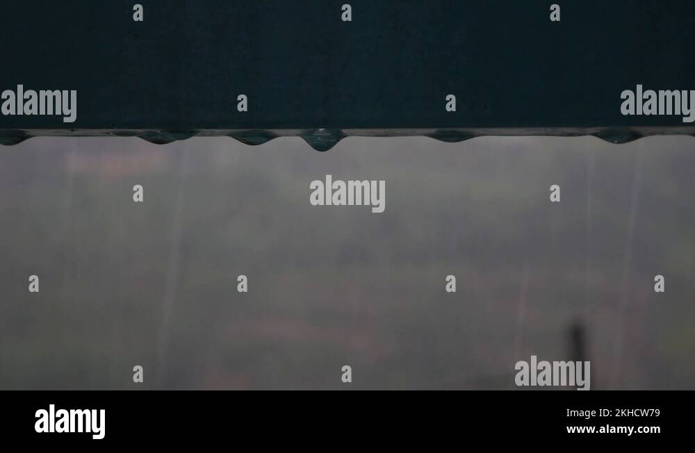 Drops of water dripping from the railing on the balcony during heavy ...