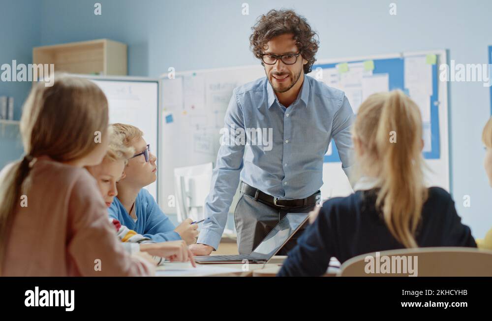 Teacher Explains Lesson to a Classroom Full of Children Having ...