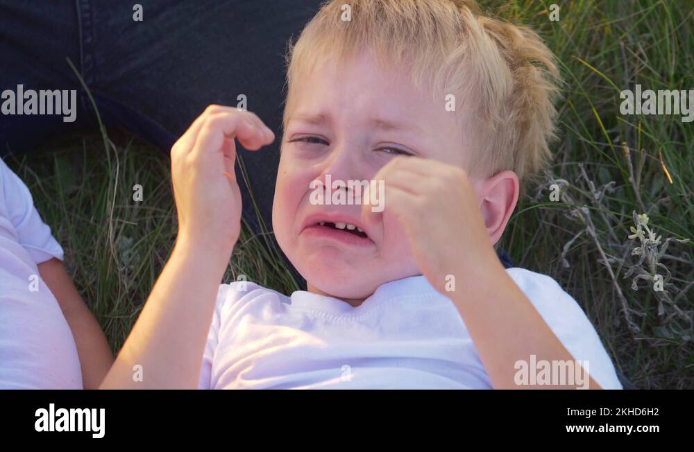 The boy is crying while lying on his mother’s lap. Family relationships ...