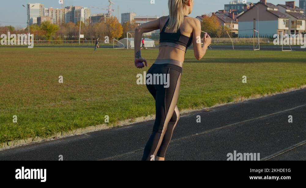 Strong Fitness Girl running in stadium. She is Celebrating the End of ...