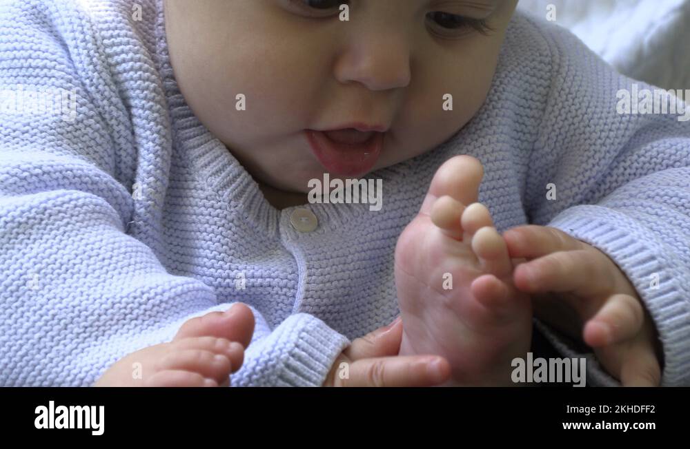 Infant putting foot in mouth and regurgitating vomiting milk Stock ...