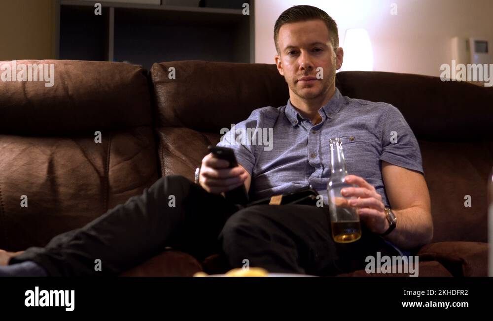 Man Changing Channels With Remote, Watching Television And Drinking ...