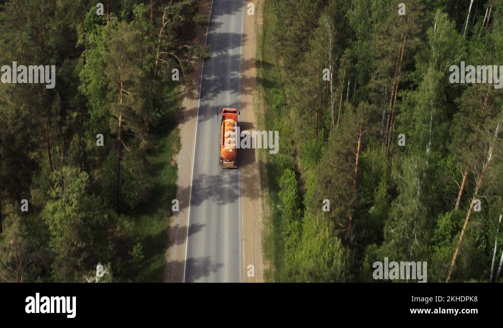 Gasoline tanker / orange fuel truck fast driving on straight freeway in ...