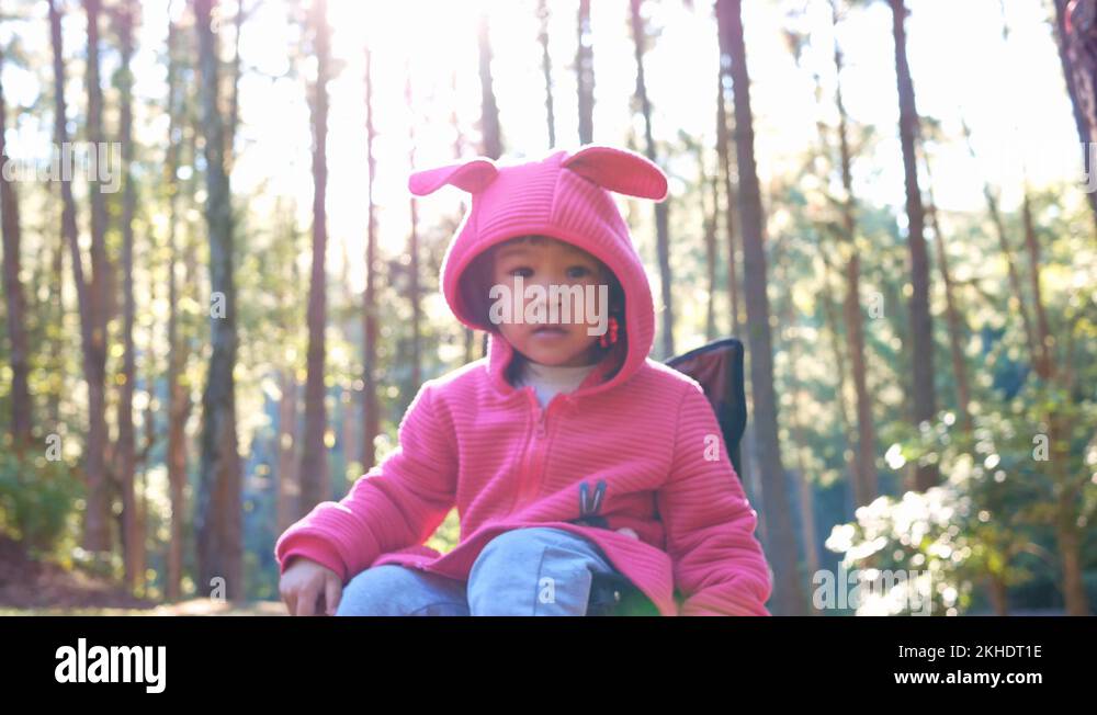 Asian little child girl sitting on the chair while going camping at ...