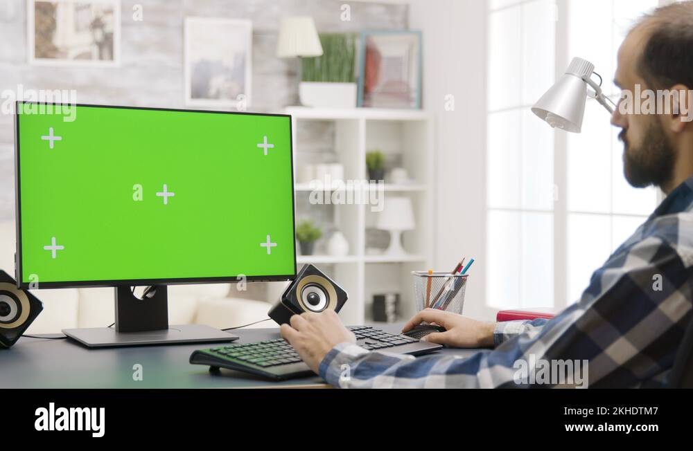 Man looks at green screen PC display in well lit home Stock Video ...