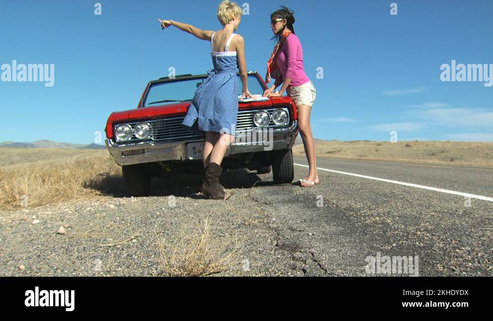 two girls looking at a map on a road trip Stock Video Footage - Alamy