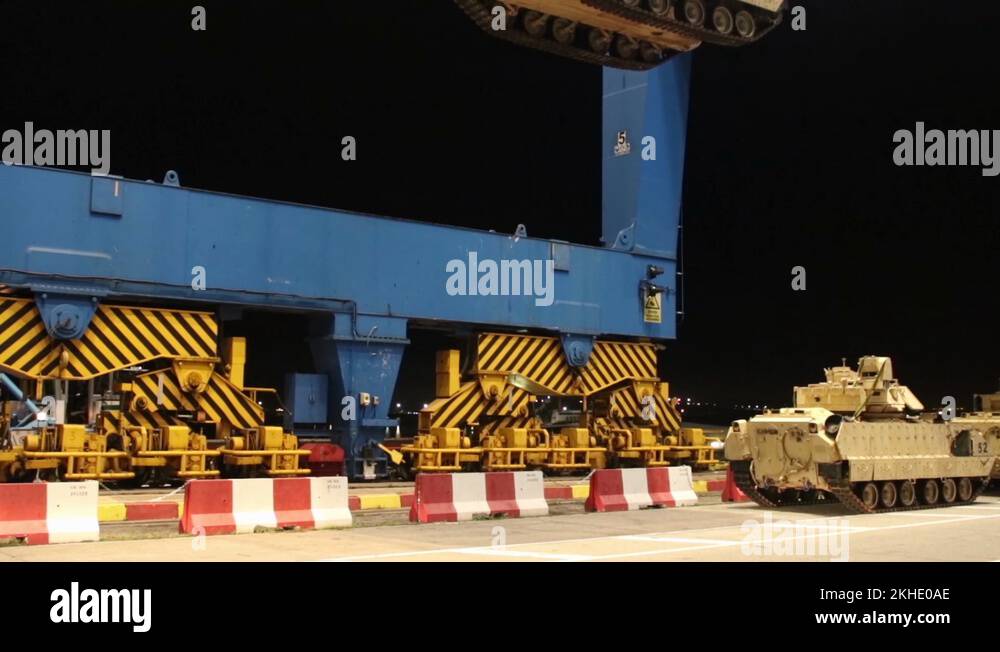 Overhead gantry crane lowering M2A3 Bradley Fighting Vehicle to ground ...