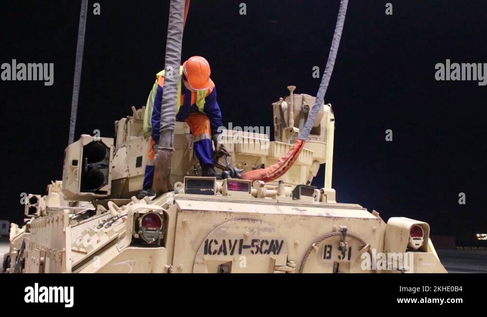 Port worker releases lifting chains from U.S. Army M2A3 Bradley ...