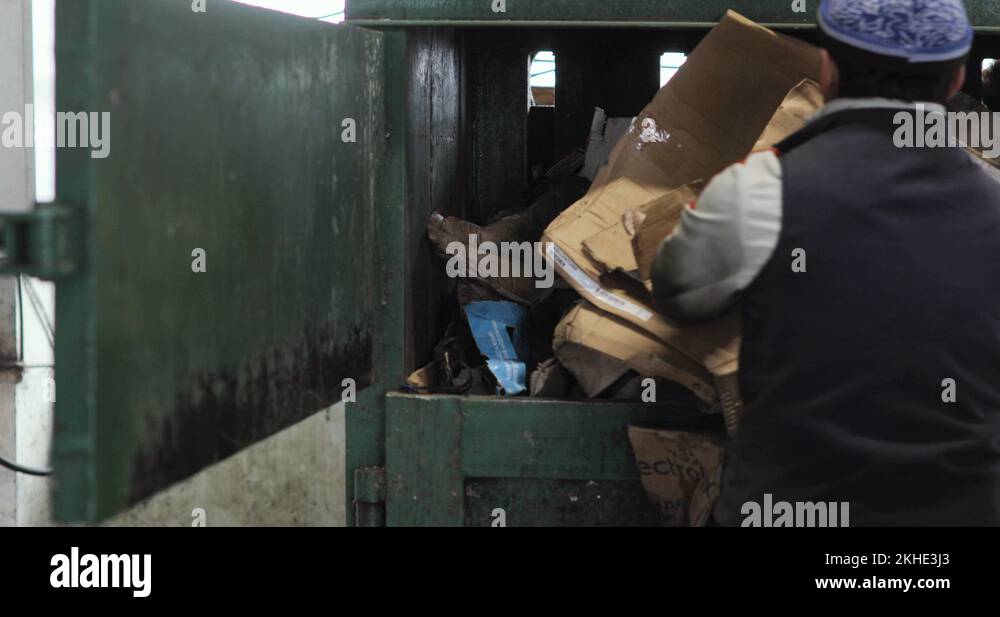 Man worker sorting putting paper cardboard garbage in container and ...