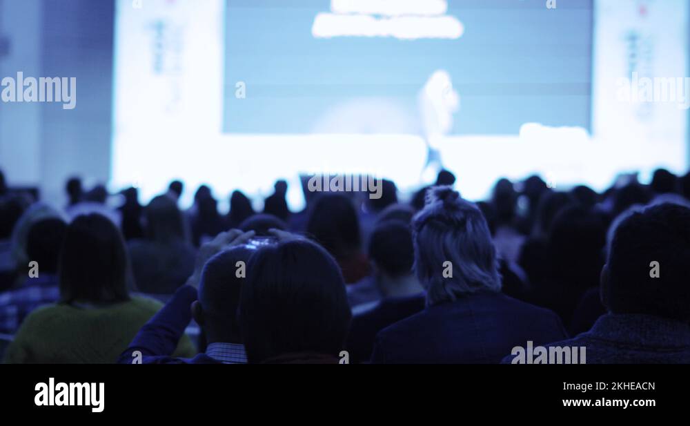 Speaker man on stage talking ans showing presentation on screen at ...