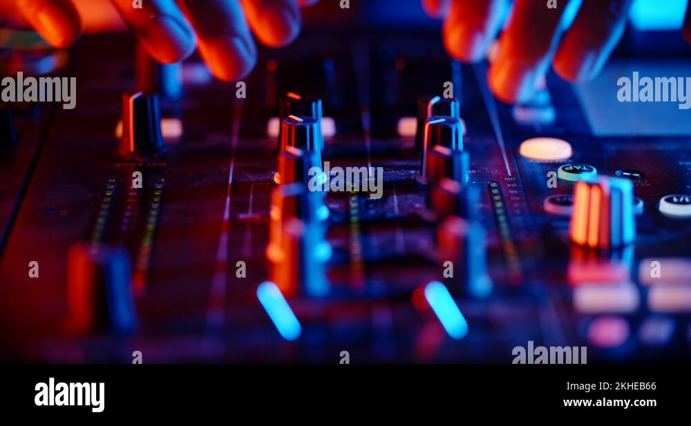 Disc jockey working on his professional mixer controller, sliding the ...