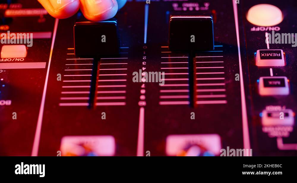 Disc jockey working on his professional mixer controller, sliding the ...