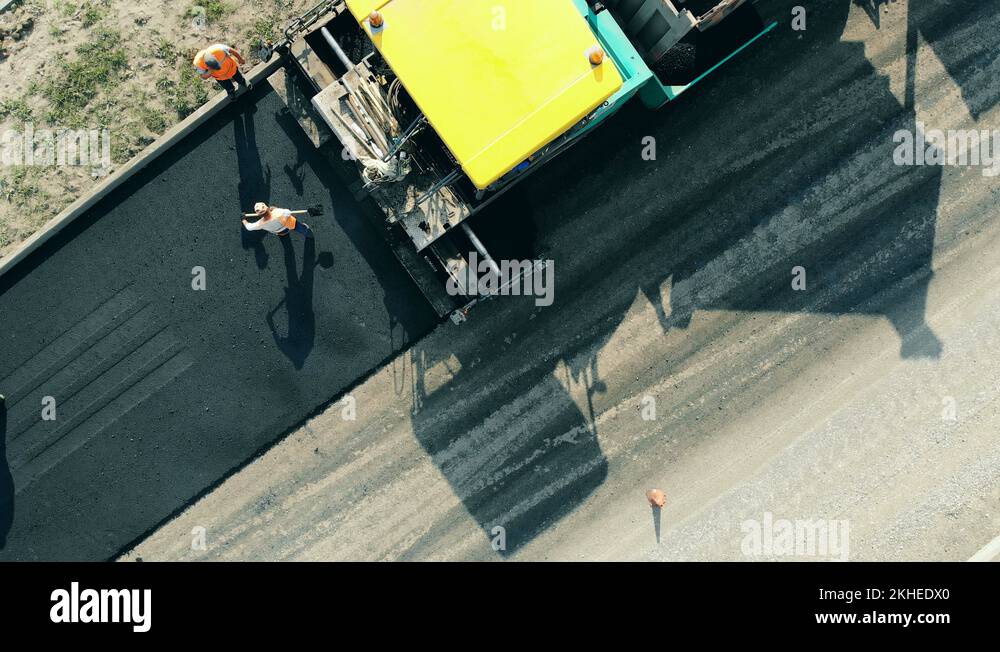 Asphalt road in progress with workers in a top view. Road construction ...