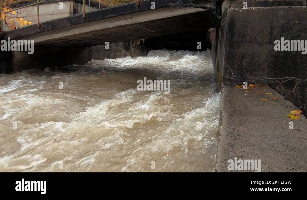 Low angle water flows in concrete channel under small bridge Stock ...