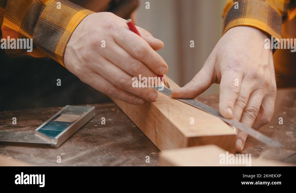 Carpentry - a woodworker making marks for cutting on the wooden detail ...