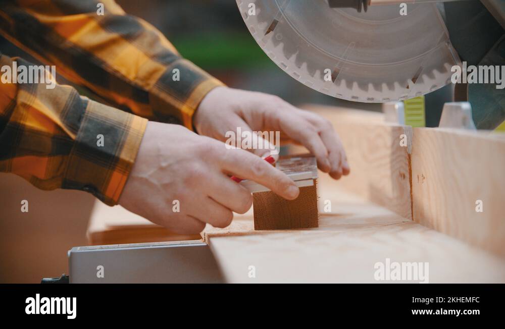 Carpentry - a man woodworker making marks for cutting on the wooden ...