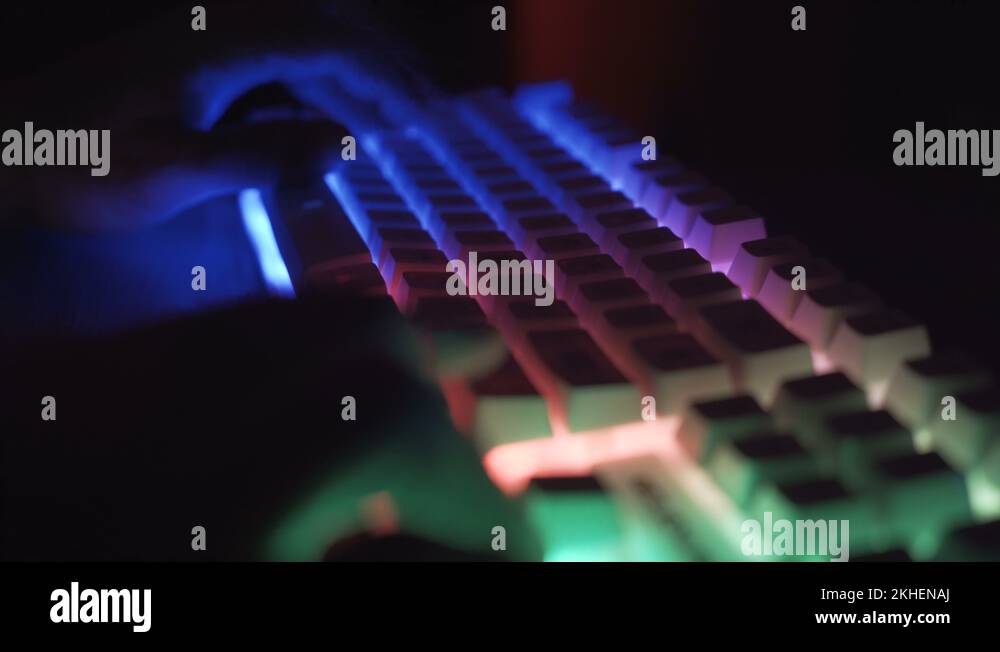 Male Gamer Typing And Pressing Keys On White Gaming Rgb Keyboard In