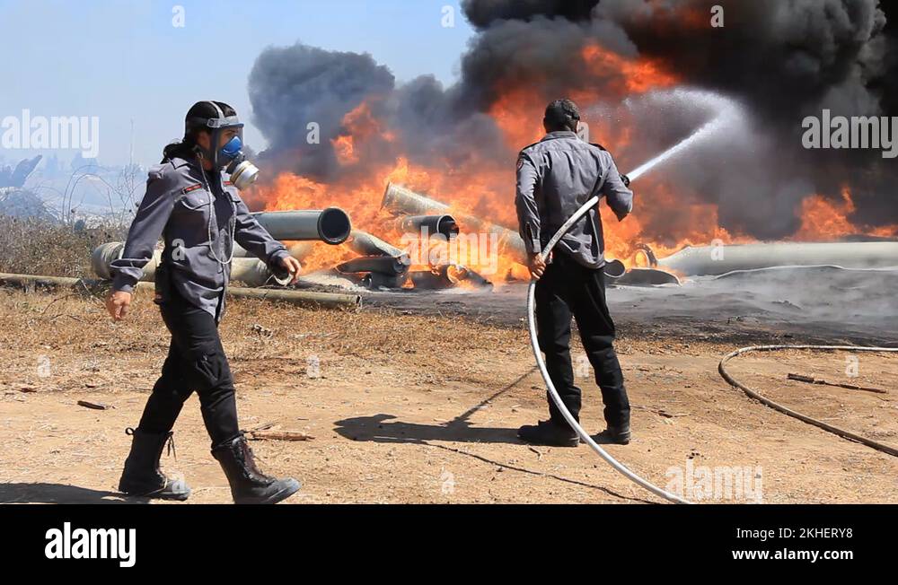 Fireman extinguishing burning grass forest Emergency flames smoke fire ...