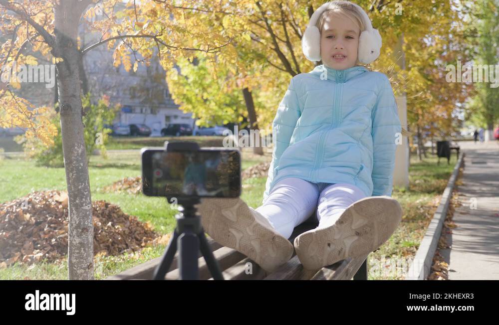 Happy cute little vlogger making online video recording vlog sitting on ...