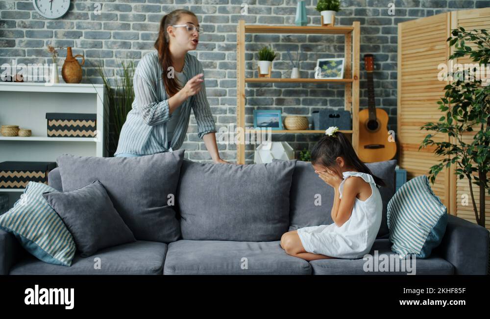 Angry mother punishing naughty daughter wagging finger while child ...