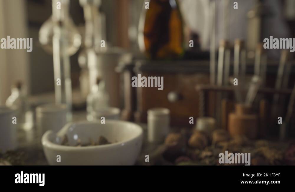 Camera moving up showing old Caucasian apothecary writing with feather ...