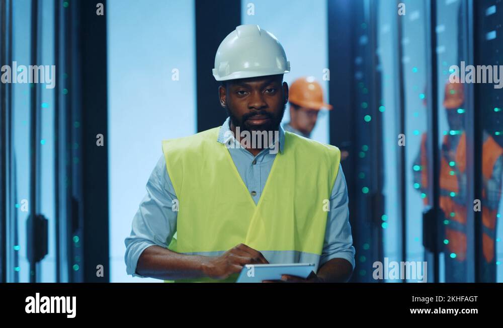Positive african technician worker cooperating in data center. Zoom ...