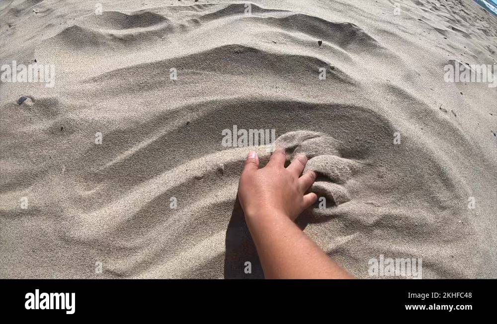 Hand movement on the sand surface, top view. Man's hand scatters Stock ...