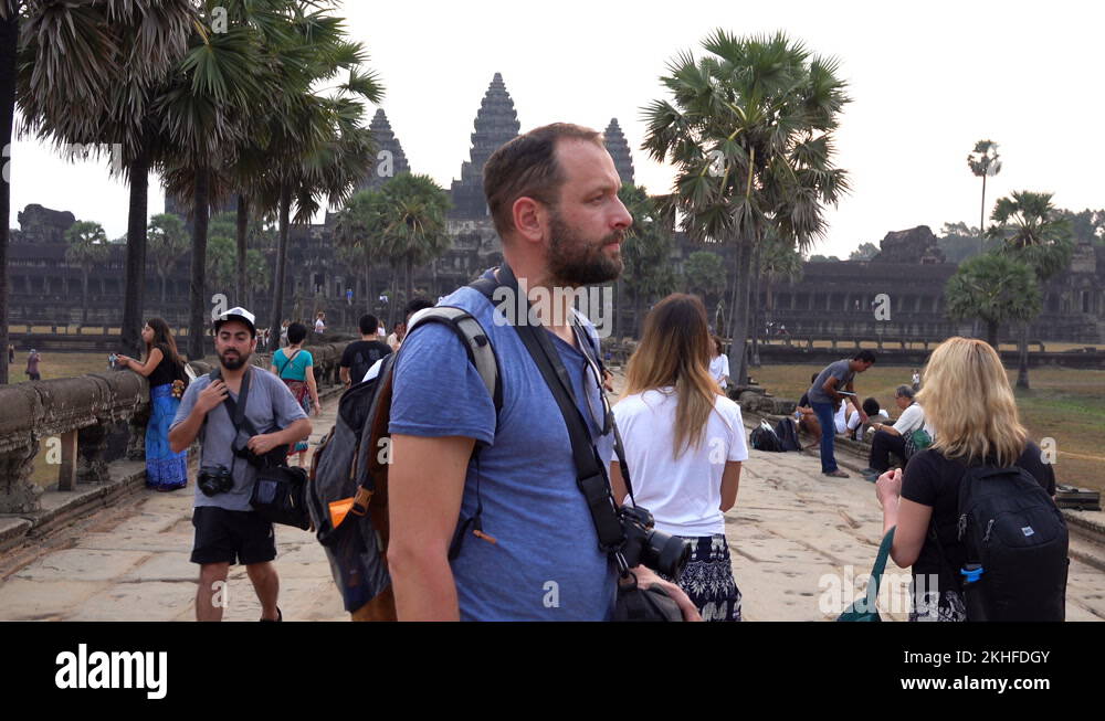 Crowd of people sightseeing ancient Angkor Wat temple ruins in Cambodia ...