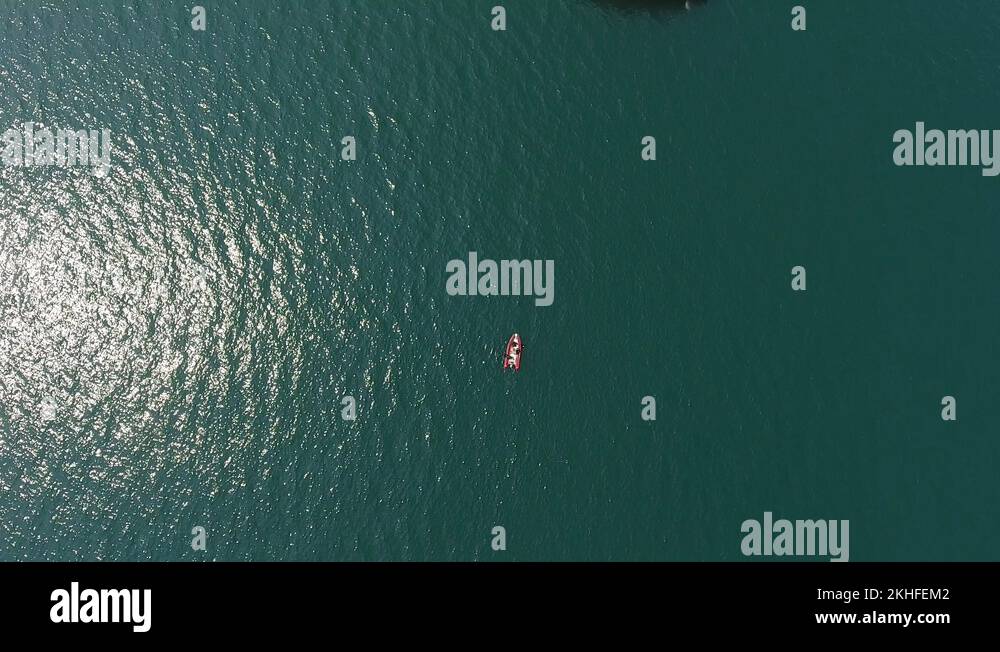 Aerial view of the water surface of sea/ocean. A motor boat far below ...
