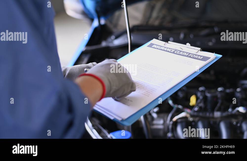 Auto mechanics reading insurance claim form document paper before ...