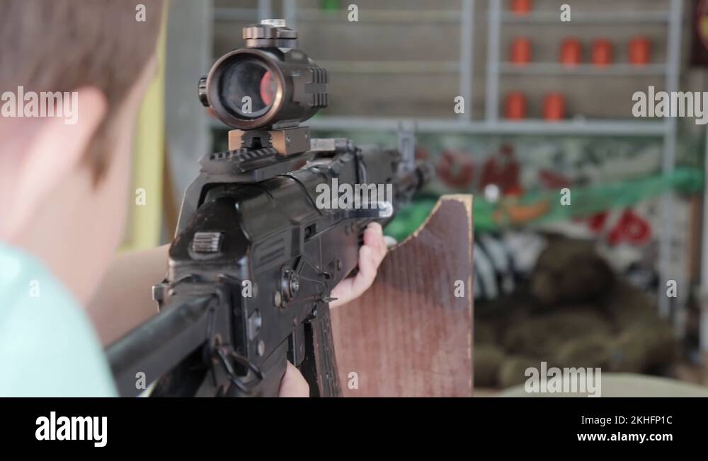 Caucasian teenage boy aiming with pneumatic rifle in shooting gallery ...