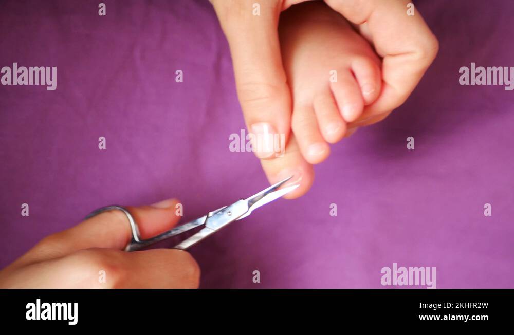 Mom cuts the toenails of the child. Close-up. child 0-1 year old. Mom ...