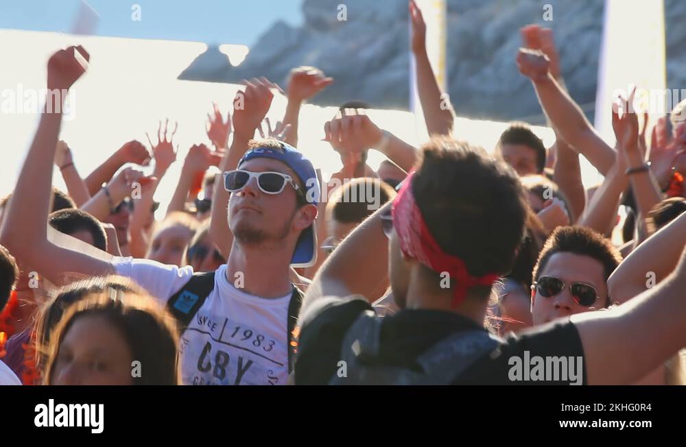 Crowd of young people dancing at the beach party. People dancing on the ...