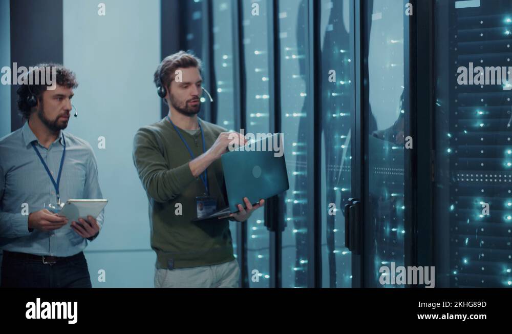 Business datacenter male team monitoring operational server cabinet ...