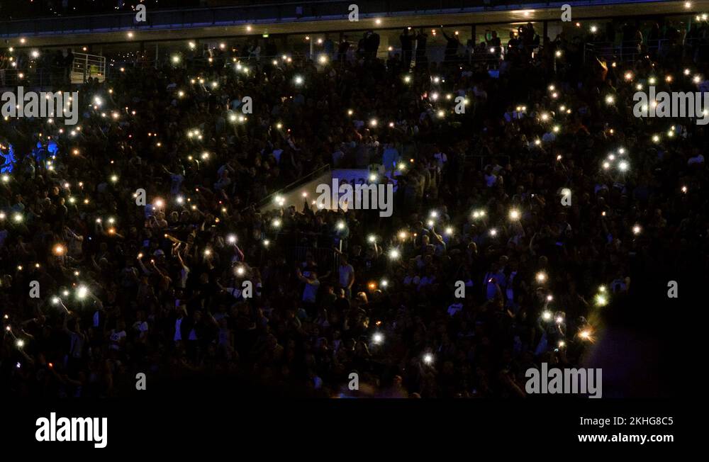 Crowd of fans standing in fan zone during rock or pop music concert. 4K ...