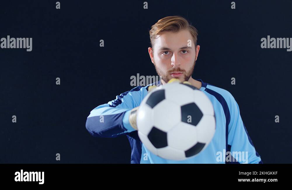 Goalkeeper soccer player showing with a ball, black background, 4k slow ...