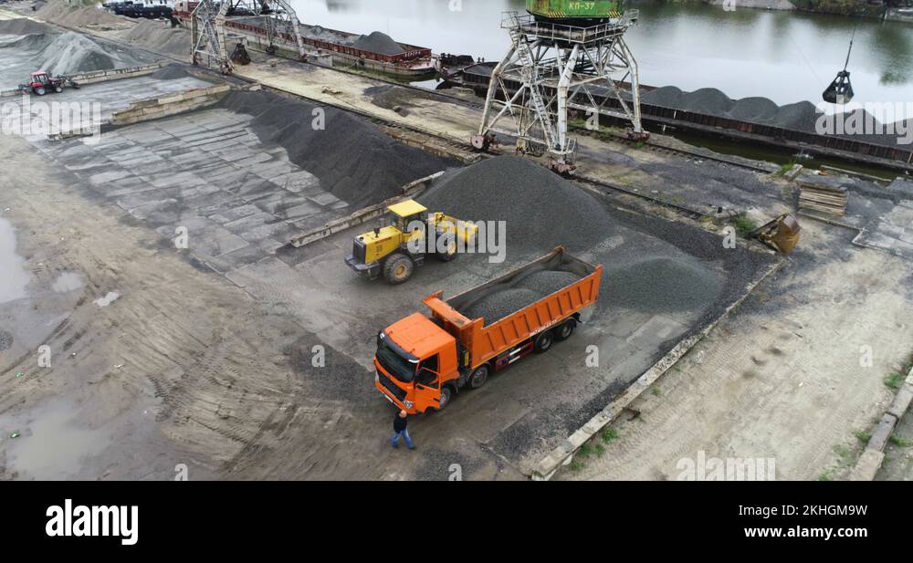 Loading a truck in the port, the excavator loads into the material in ...