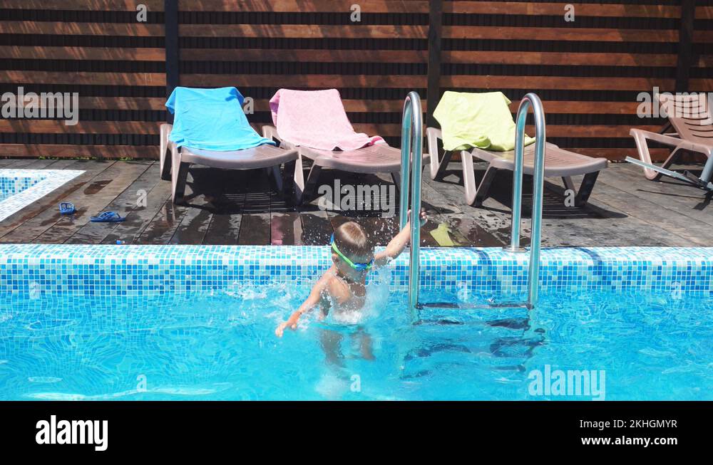 Small little boy jumping diving into swimming pool water. Little boy in ...