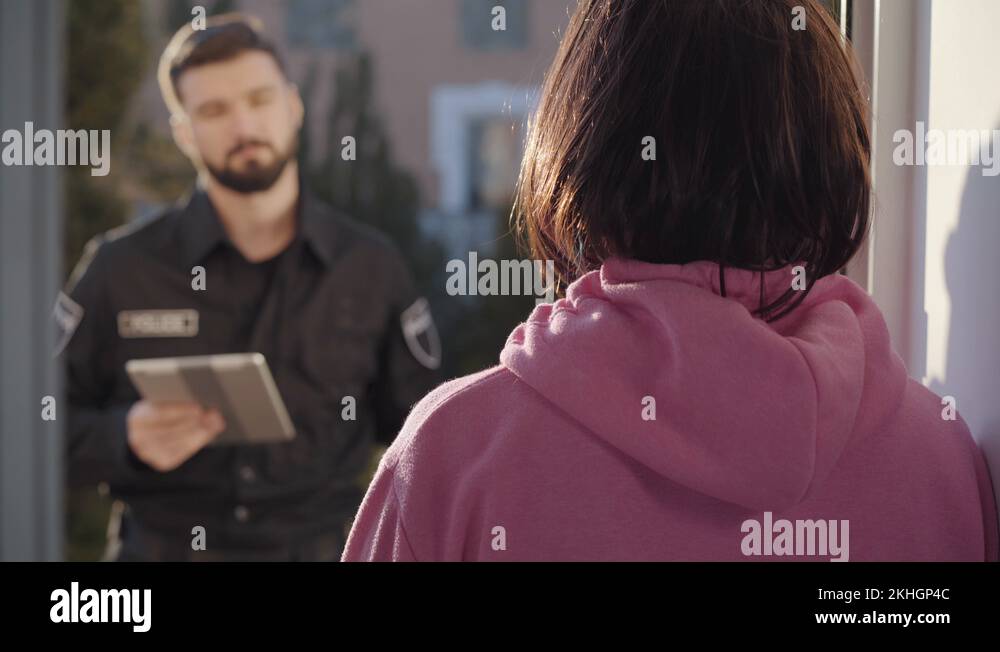 Back view of young unrecognizable Caucasian woman talking with police ...