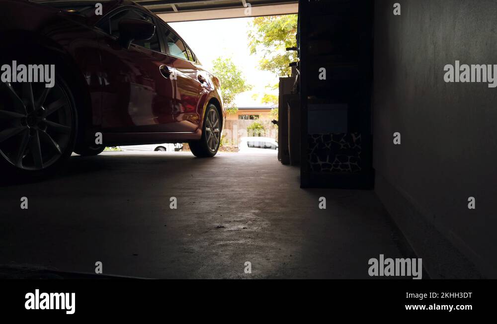 man getting out of a car in the garage and walking inside with door ...