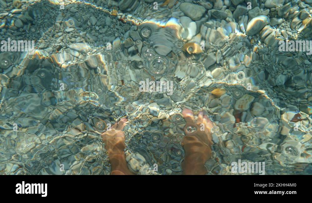 close-up. human legs in water. under the clear water of the Aegean Sea ...