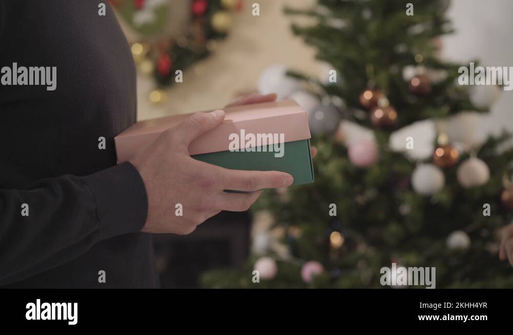 Camera following gift box given by male Caucasian hands to young ...