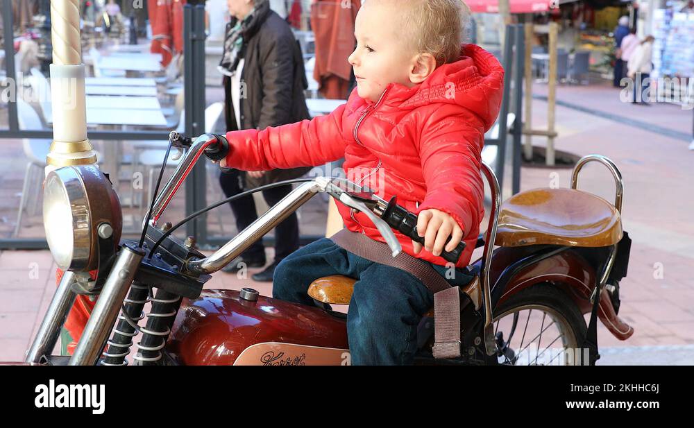 Baby Boy Sitting On A Vintage Motorcycle In A Carousel Merry-Go-Round ...
