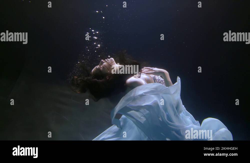 magic fairy is floating underwater in depth of swimming pool in ...