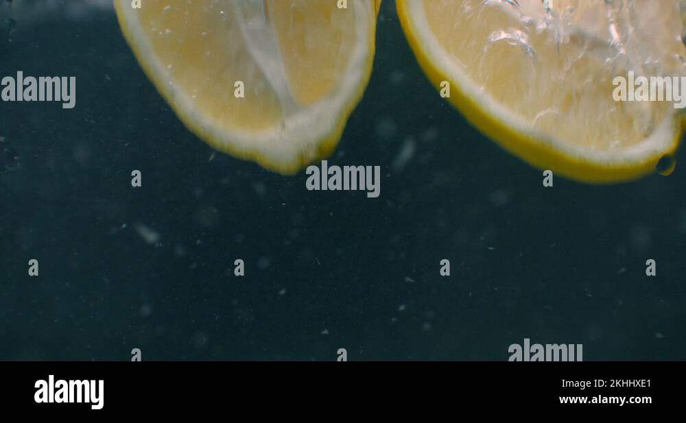 Several lemon fruits fall inside a water tank and disturb water. Three ...