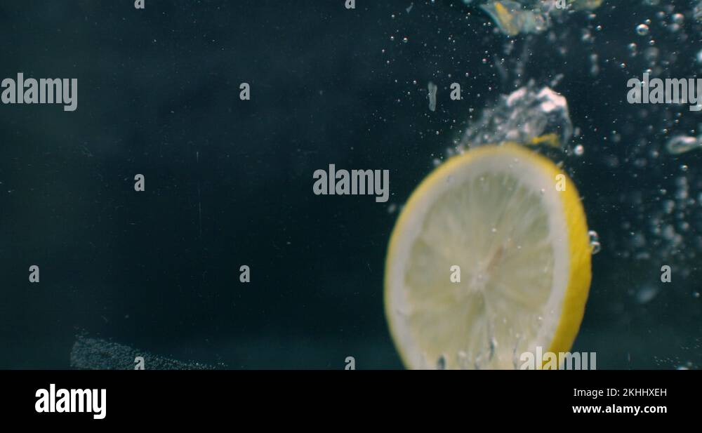 Several lemon fruits fall inside a water tank and disturb water. Three ...