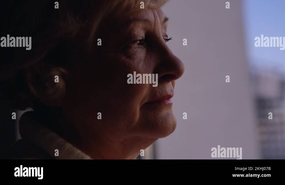 Upset elderly lady wiping tears, crying alone near window, loneliness ...