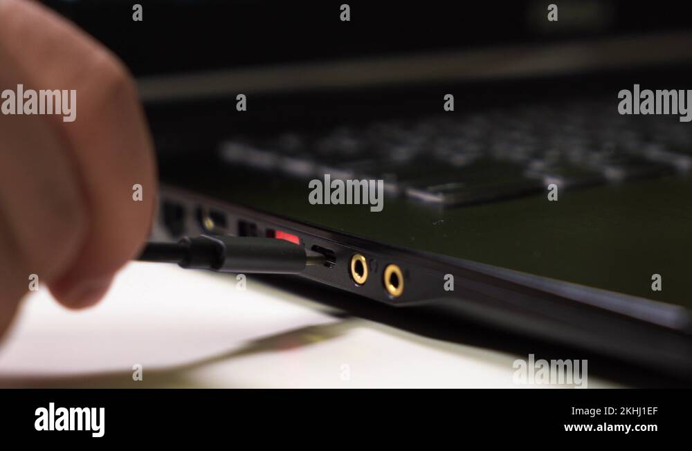 Close up male hand connect gray and black type-c cable to laptop with ...